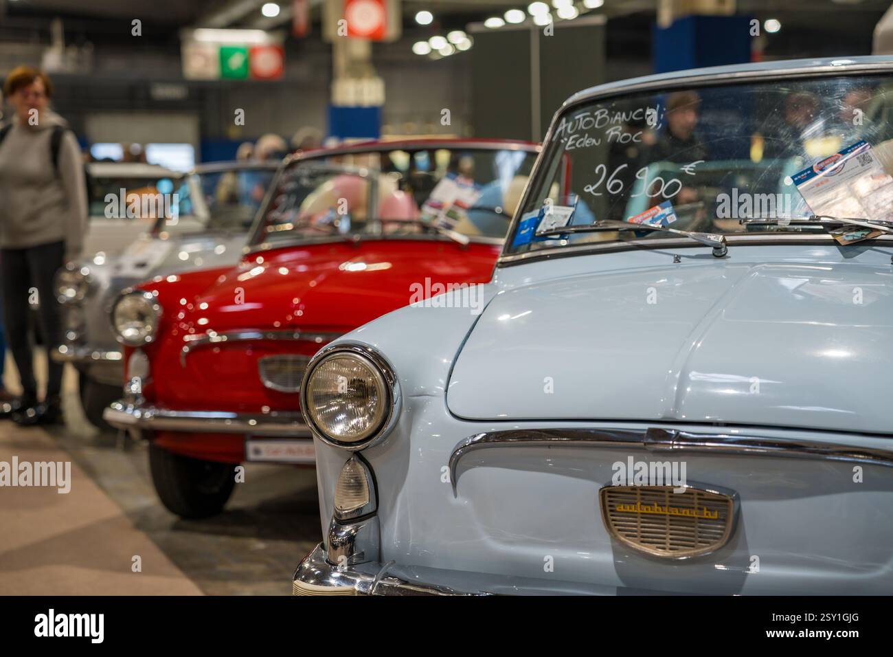 Classic car enthusiasts gather at vintage auto show in bustling indoor ...