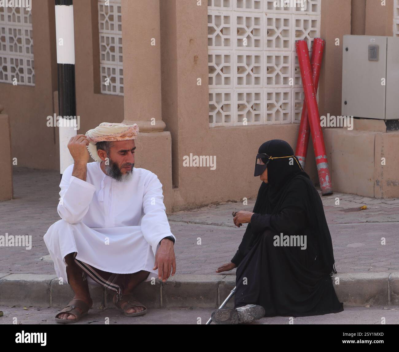 Omani Man and Woman wearing Traditional Clothes sitting on step having a Conversation Nizwa ...