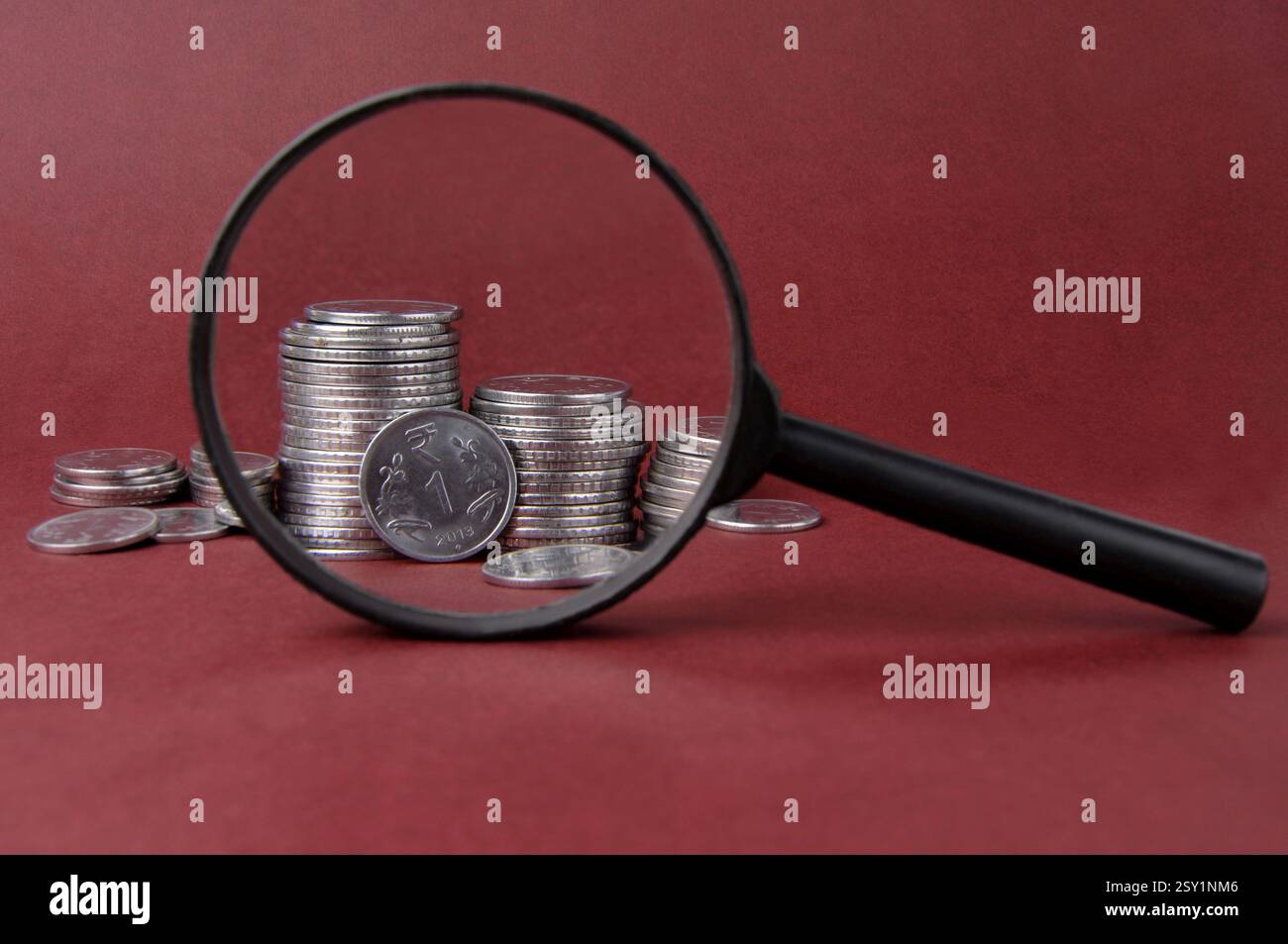 Concept of Magnifier and coin Stock Photo - Alamy