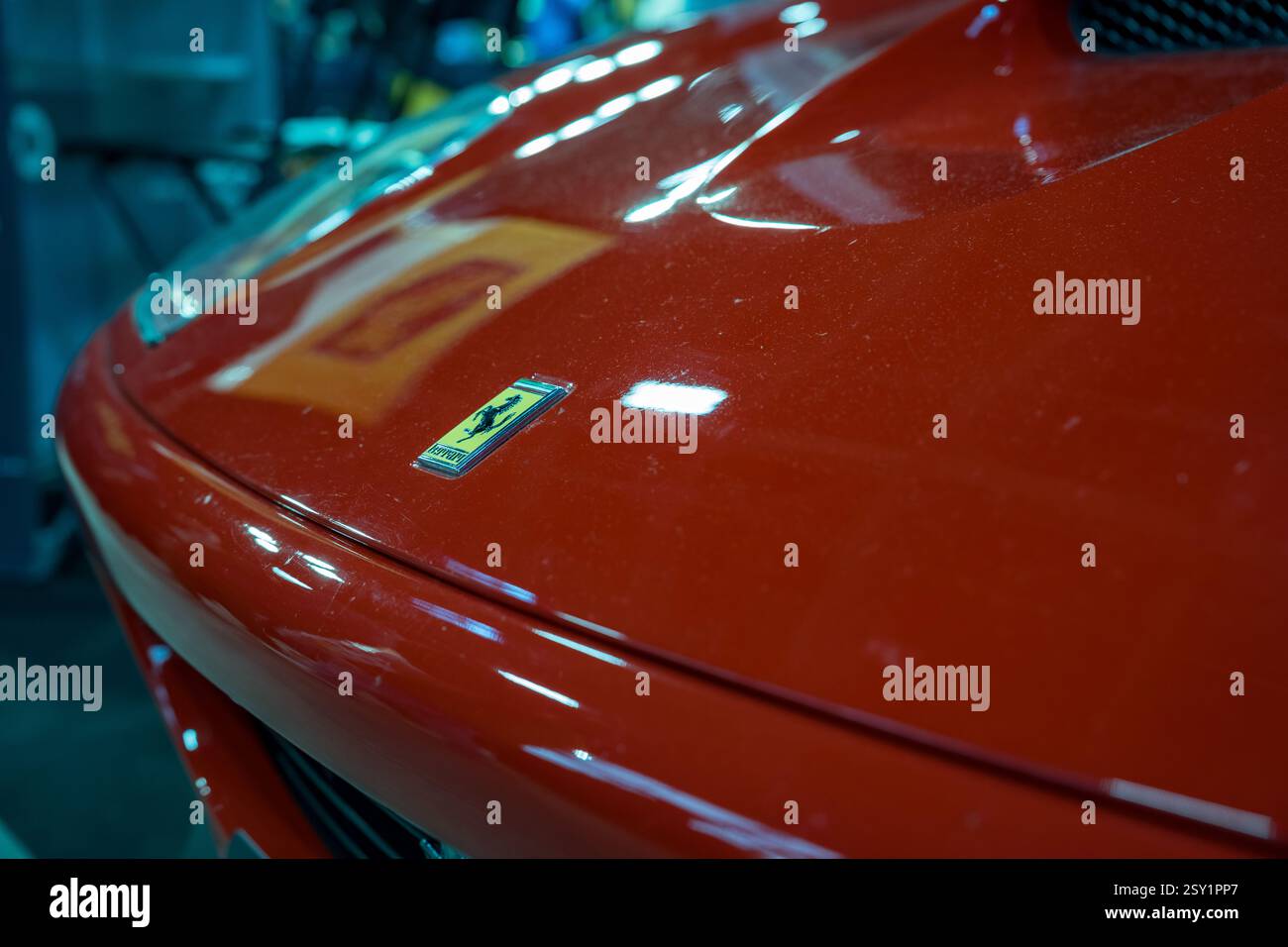Vibrant red sports car with gleaming details showcased in a workshop ...