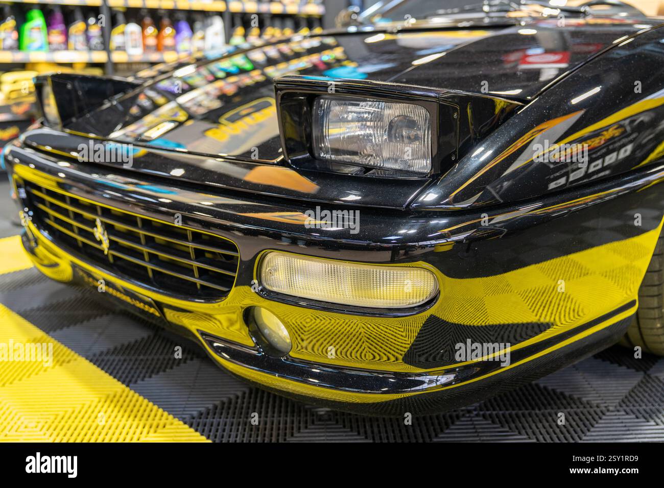Luxury sports car gleaming under showroom lights as enthusiasts admire ...