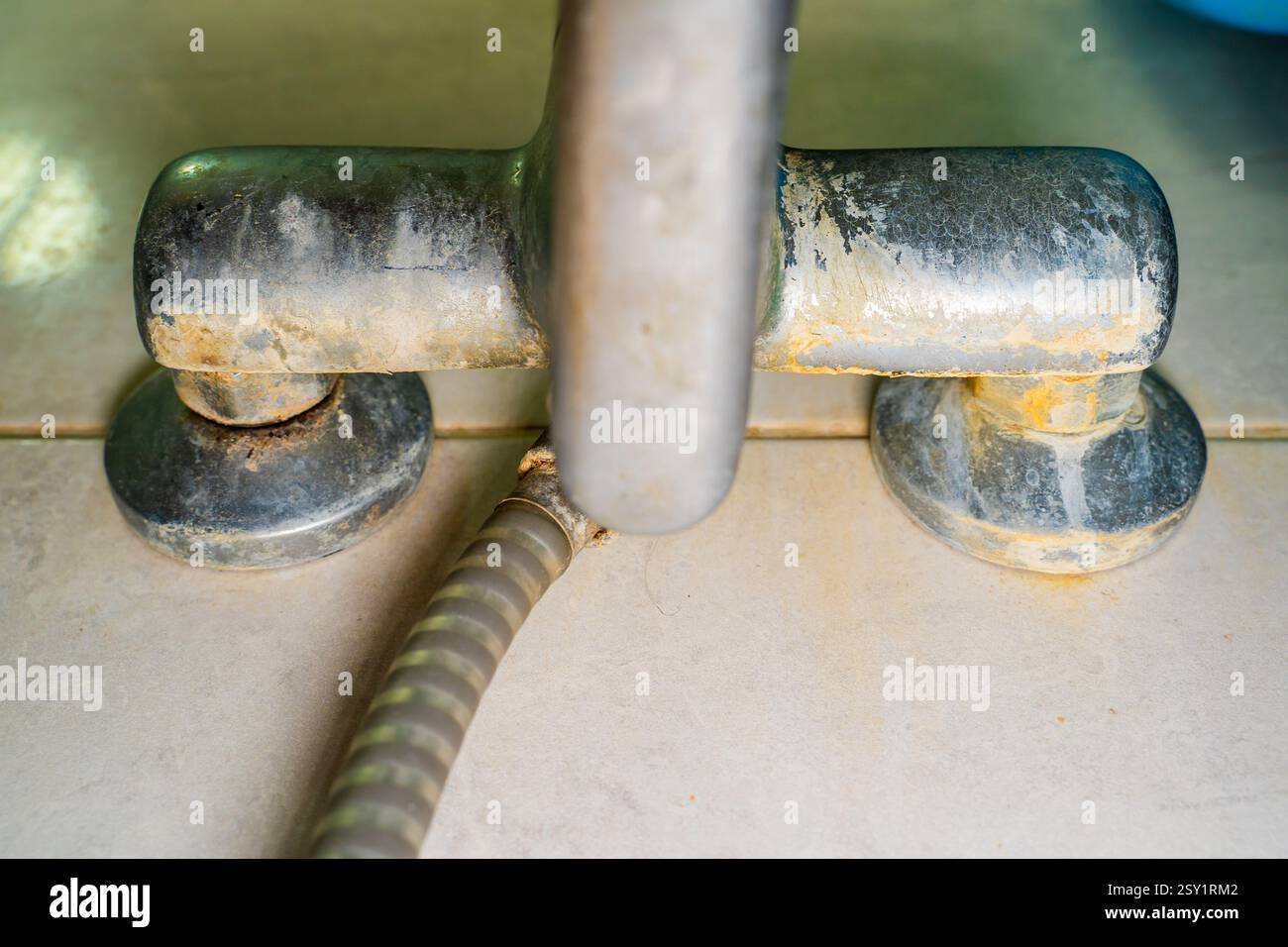 Bathroom faucet covered in scale and corrosion close-up, bottom view ...