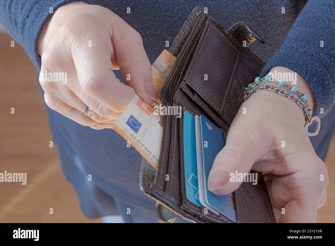 Adult woman`s hands holding a wallet with several credit cards and ...