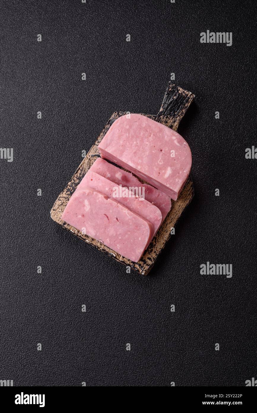 Delicious canned pink ham with salt, spices and herbs on a dark ...