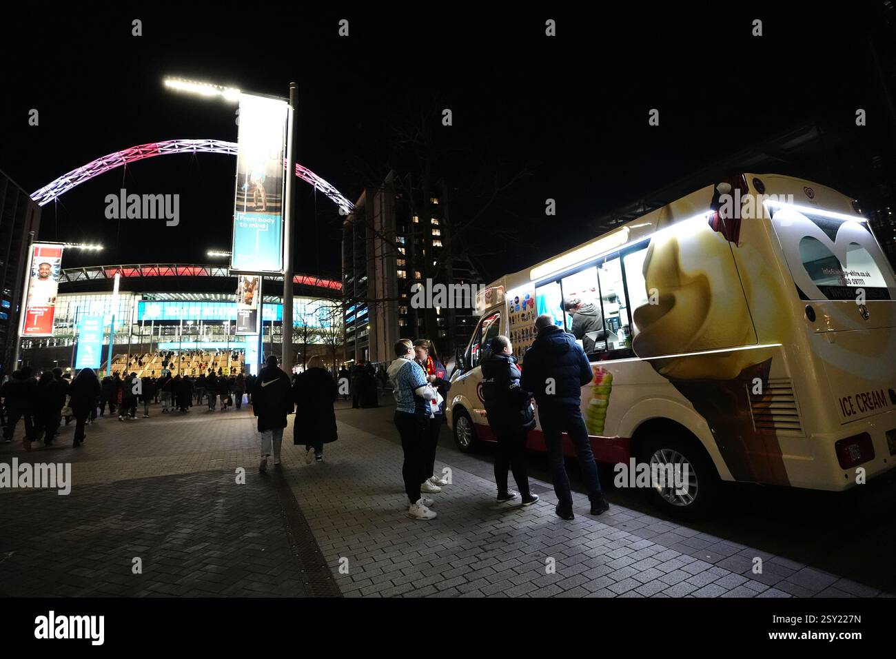 Fans queue up by an ice cream truck outside the stadium before the UEFA ...