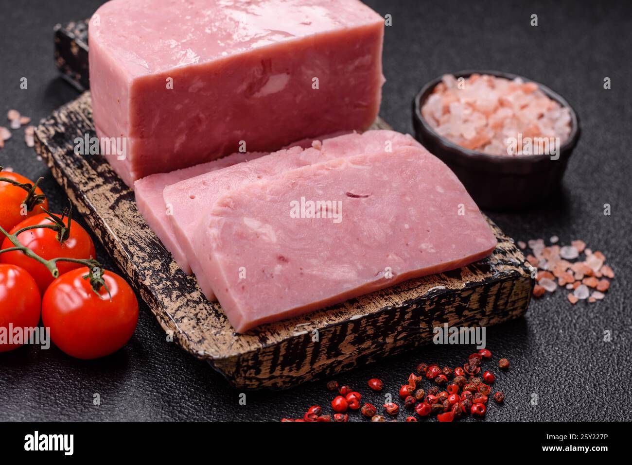 Delicious canned pink ham with salt, spices and herbs on a dark ...