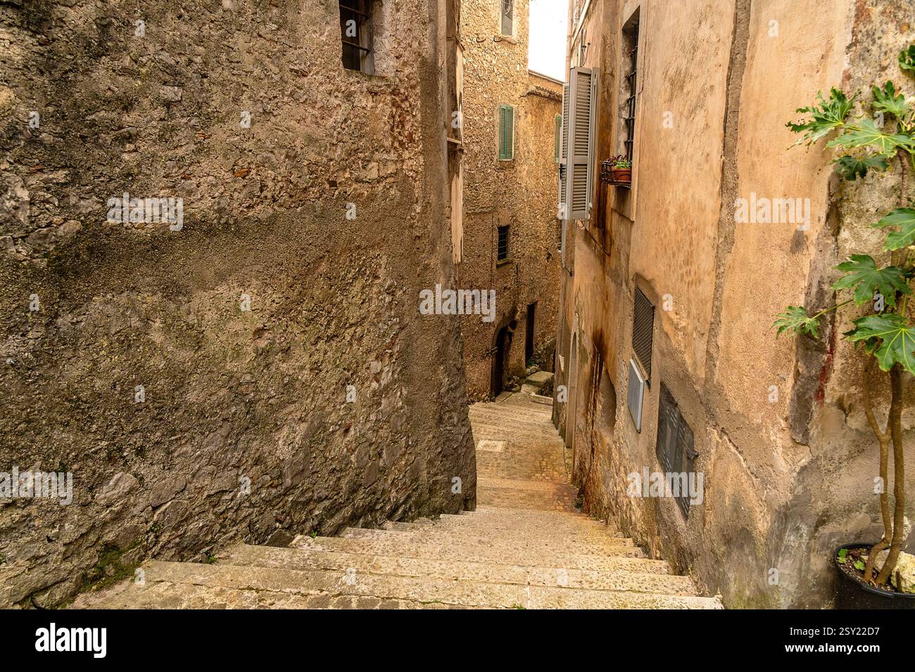 staircase descends between two rows of ancient medieval stone buildings ...