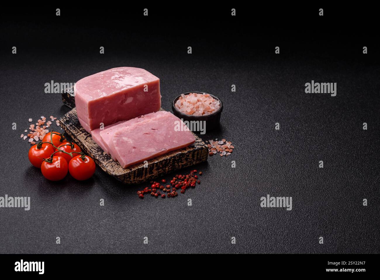 Delicious canned pink ham with salt, spices and herbs on a dark ...