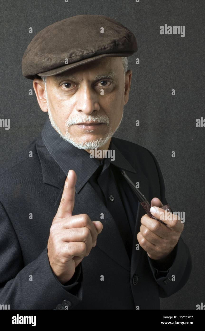 Portrait of maharashtrian elderly man holding smoking pipe in left hand ...