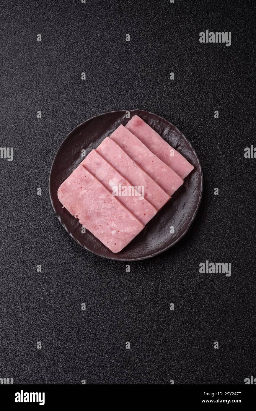 Delicious canned pink ham with salt, spices and herbs on a dark ...