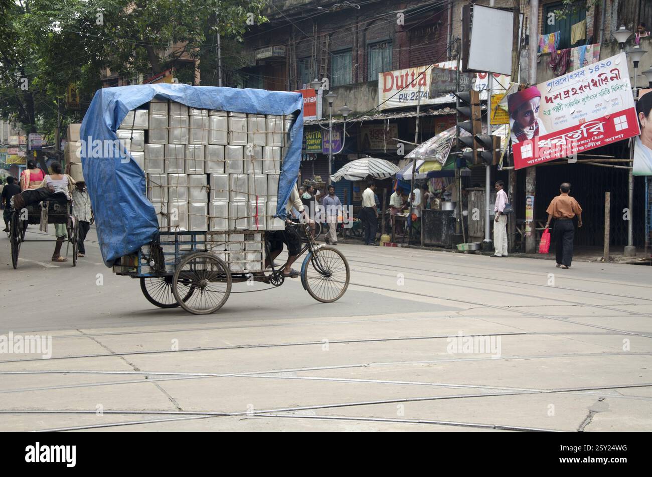 Man carrying tin canisters on cycle rickshaw Kolkata West Bengal India ...