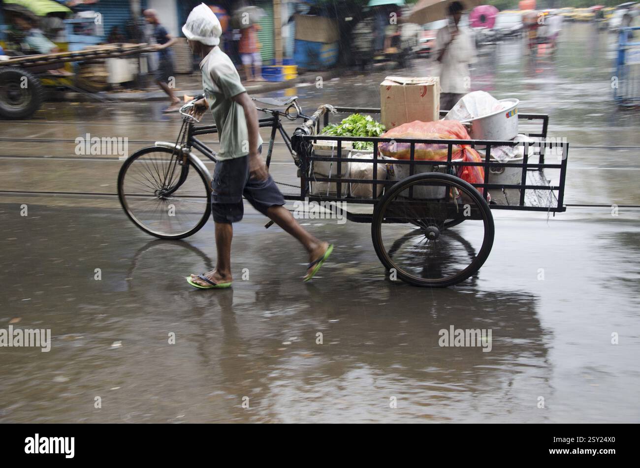 Man dragging tricycle with luggage on street in Kolkata at West Bengal ...