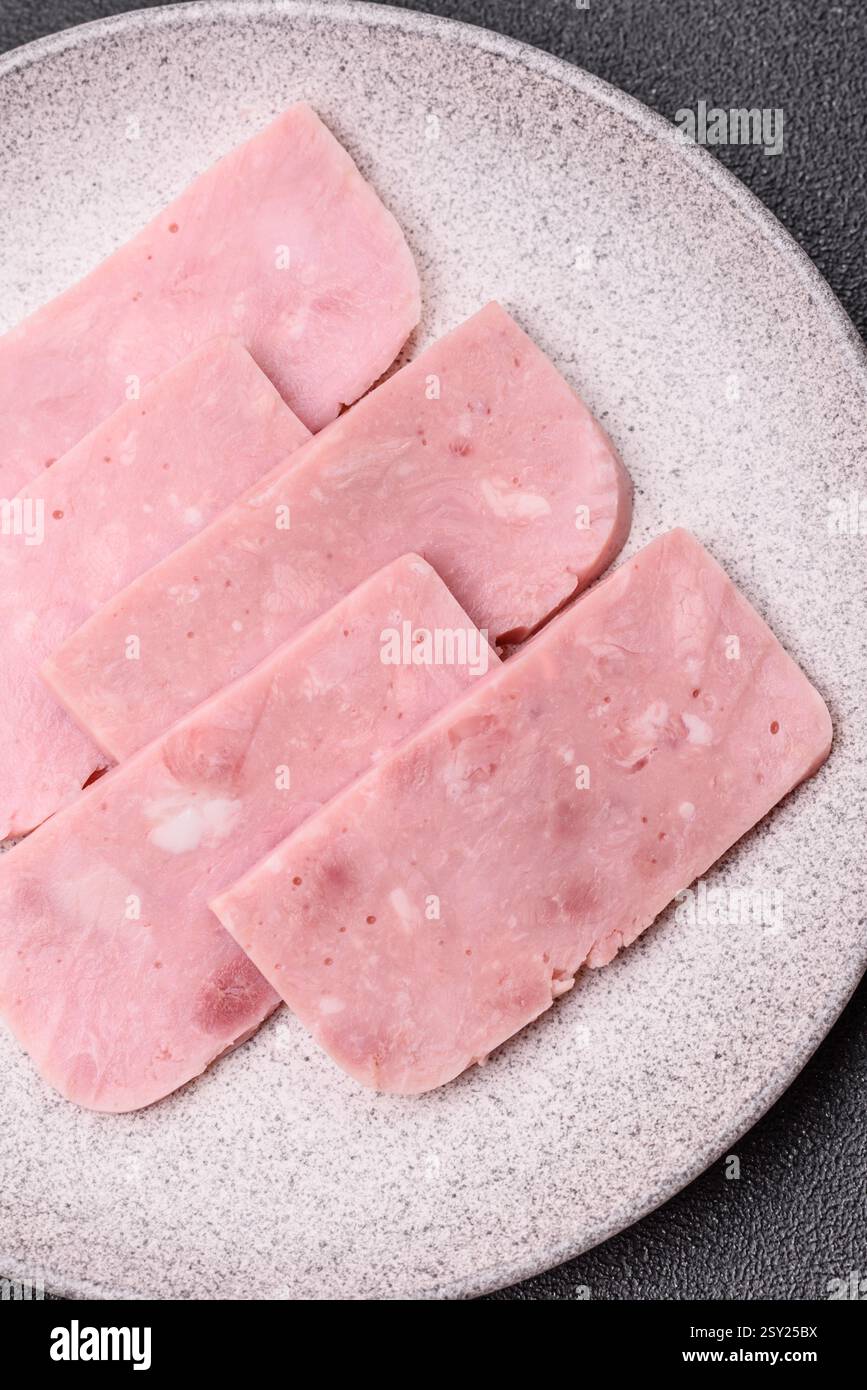 Delicious canned pink ham with salt, spices and herbs on a dark ...