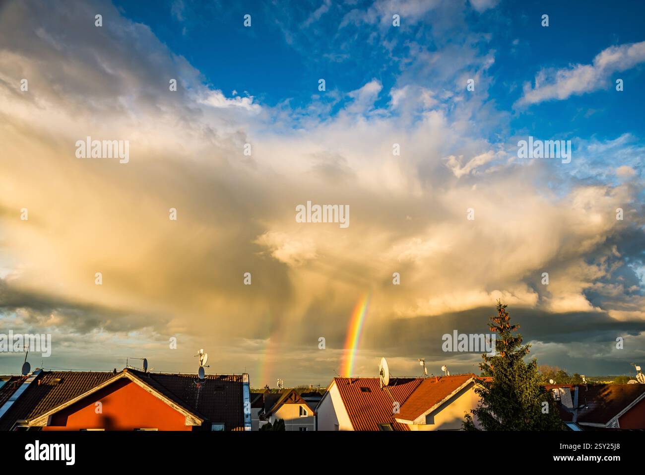 Nupaky, Czech republic - May 17, 2021. Double rainbow of cumulonimbus with blue sky in ...
