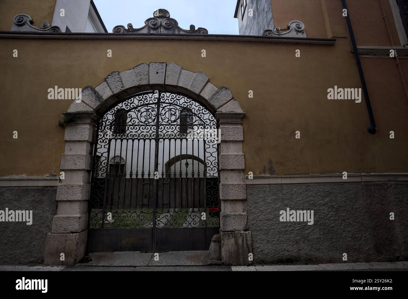 Closed iron gate in the facade of a palace with the inner yard behind ...