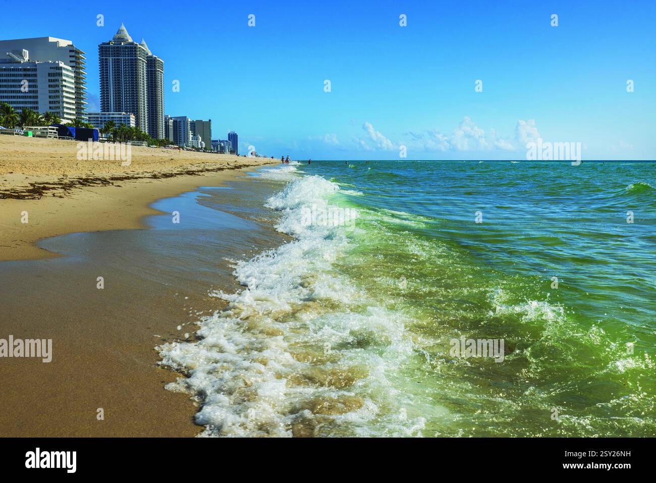 Emerald green waves of Atlantic Ocean rolling onto sandy shore in Miami ...