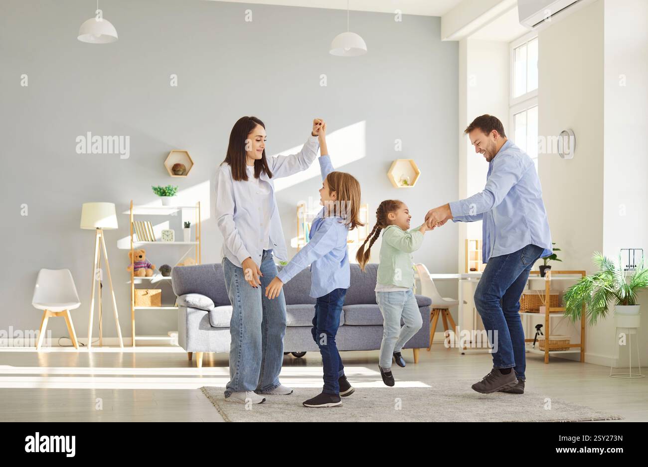 Happy family fun at home, parents entertaining dancing with little kids ...