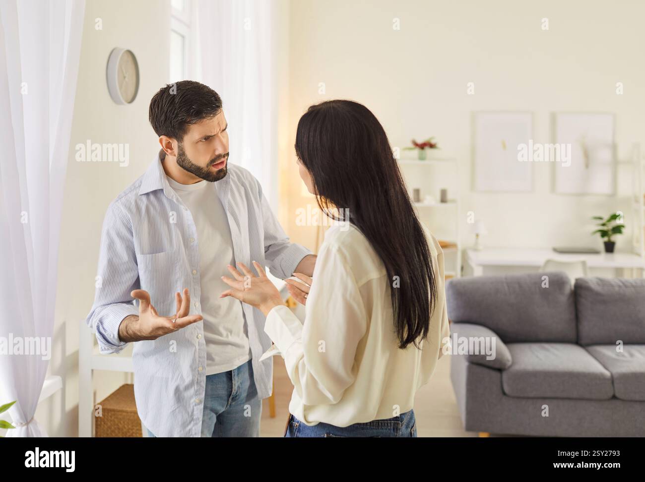 Young family couple arguing in living room, showing frustration and ...