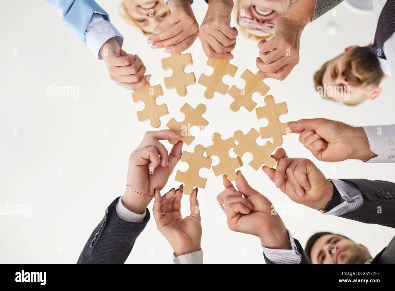 Group of business people assembling jigsaw puzzle at office ...
