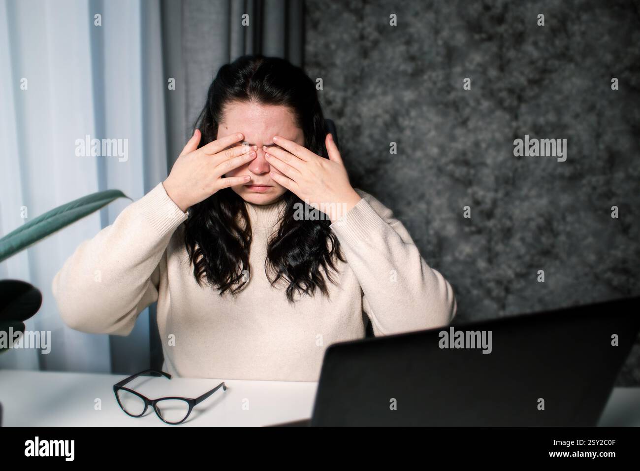 Symptoms of overworking. Young tired female freelancer in eyeglasses ...