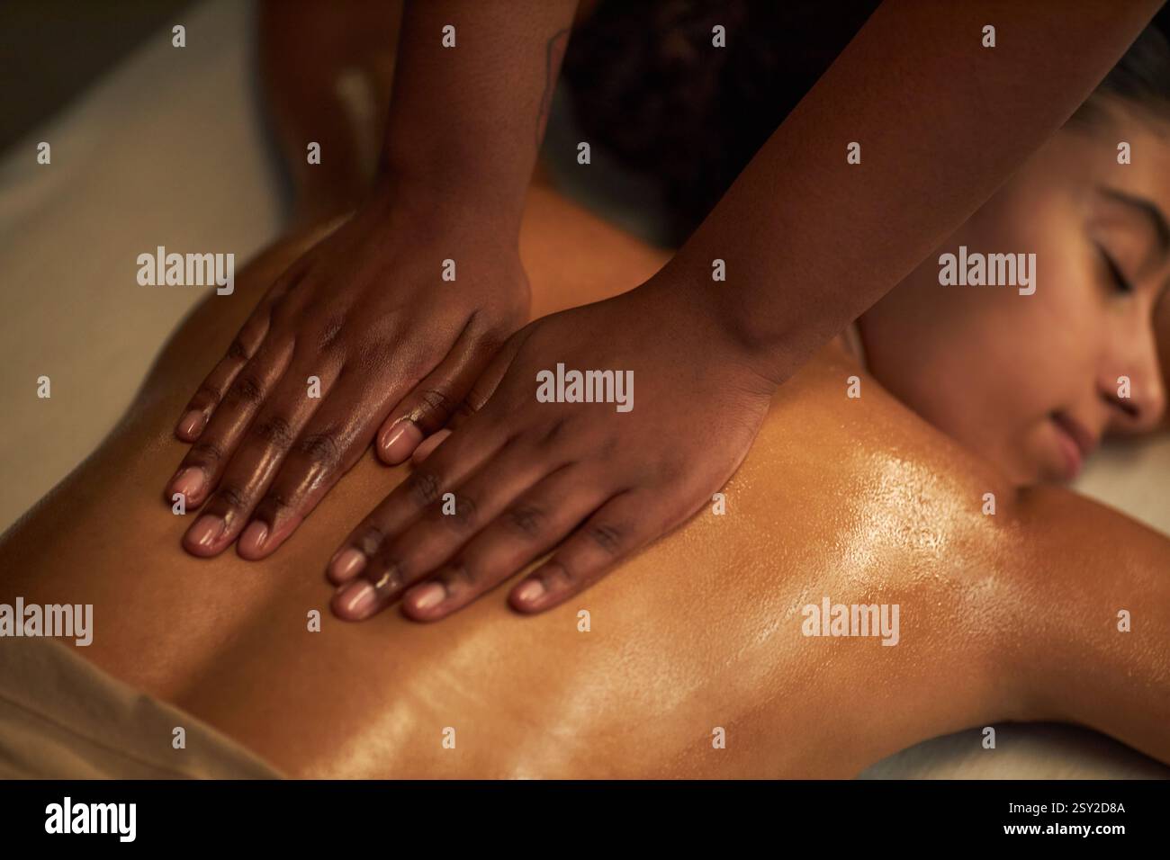 Person lying face down on massage table while receiving therapeutic ...