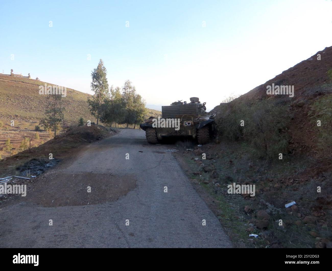 Daraa, Syria. 26th Feb, 2025. A damaged Syrian armored vehicle sits ...