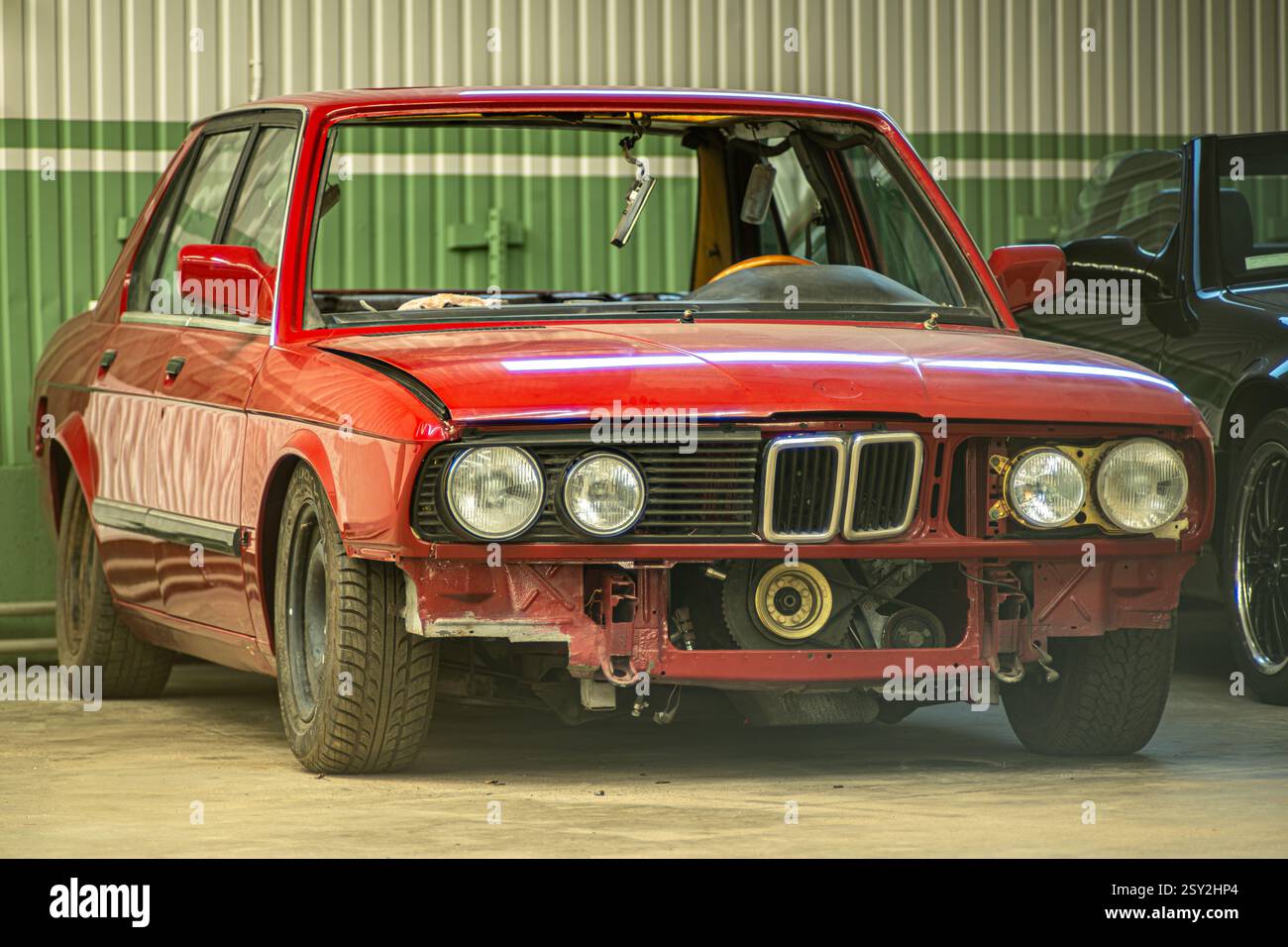 Riga, Latvia - February 2, 2025: A classic, vibrant red car featuring a ...