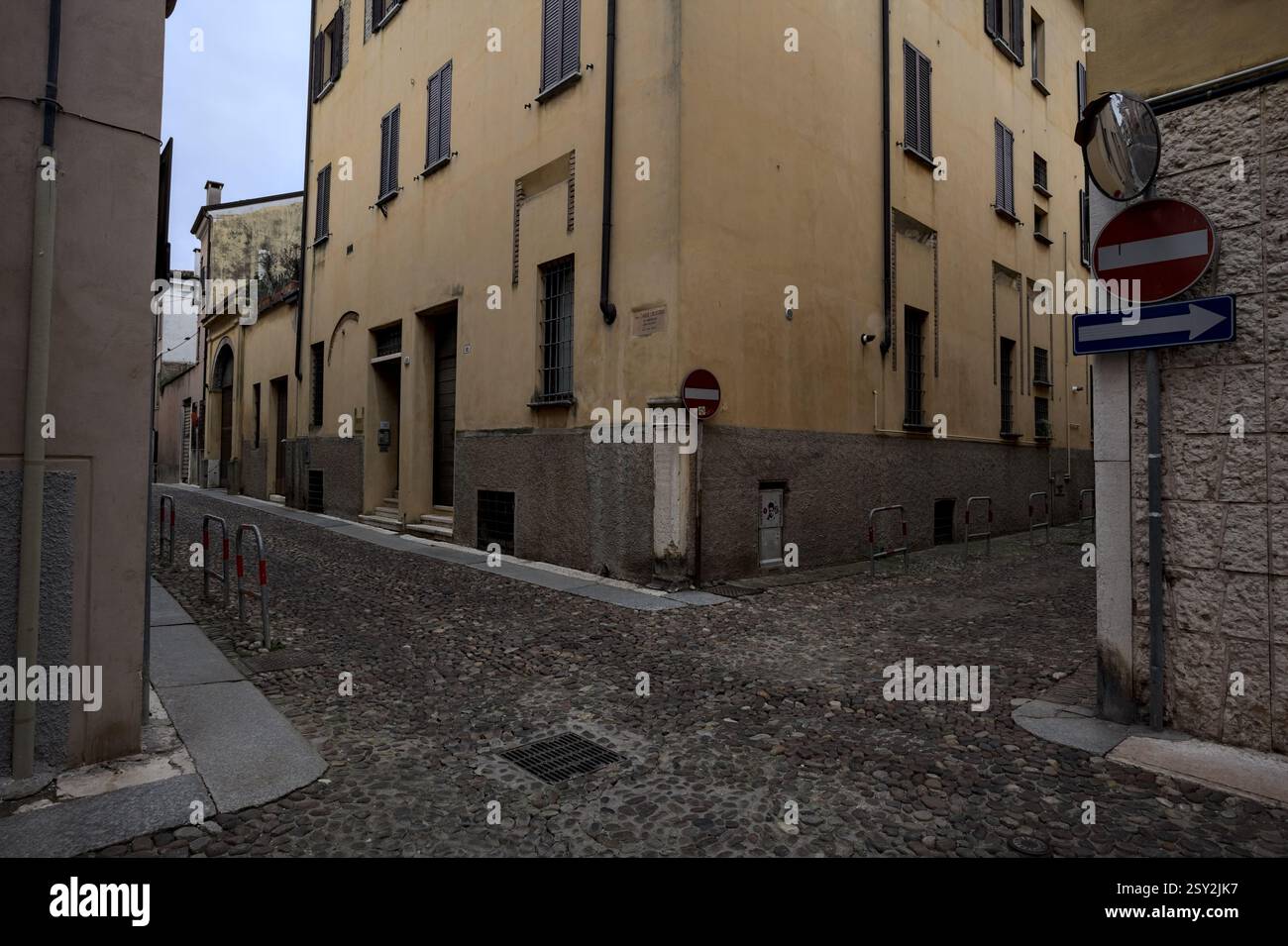 Crossing between cobbled streets partly in the shade at the corner of a ...