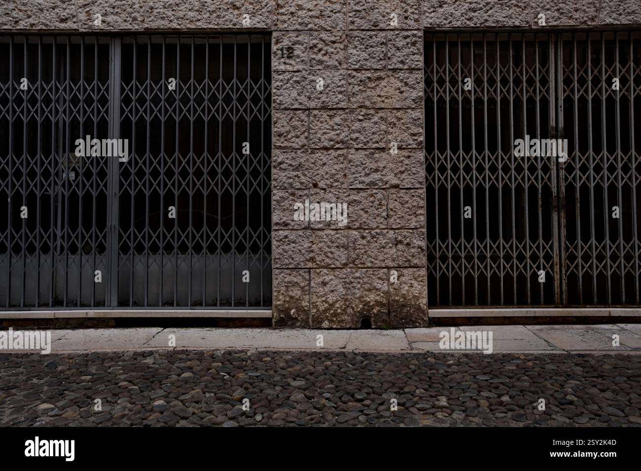 Shop windows blocked by shutters in the facade of a building in a ...