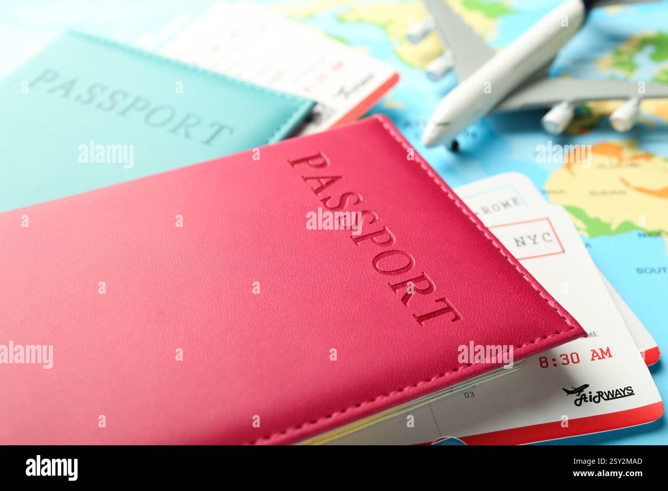 Passports in color covers, flight tickets and plane model on world map ...