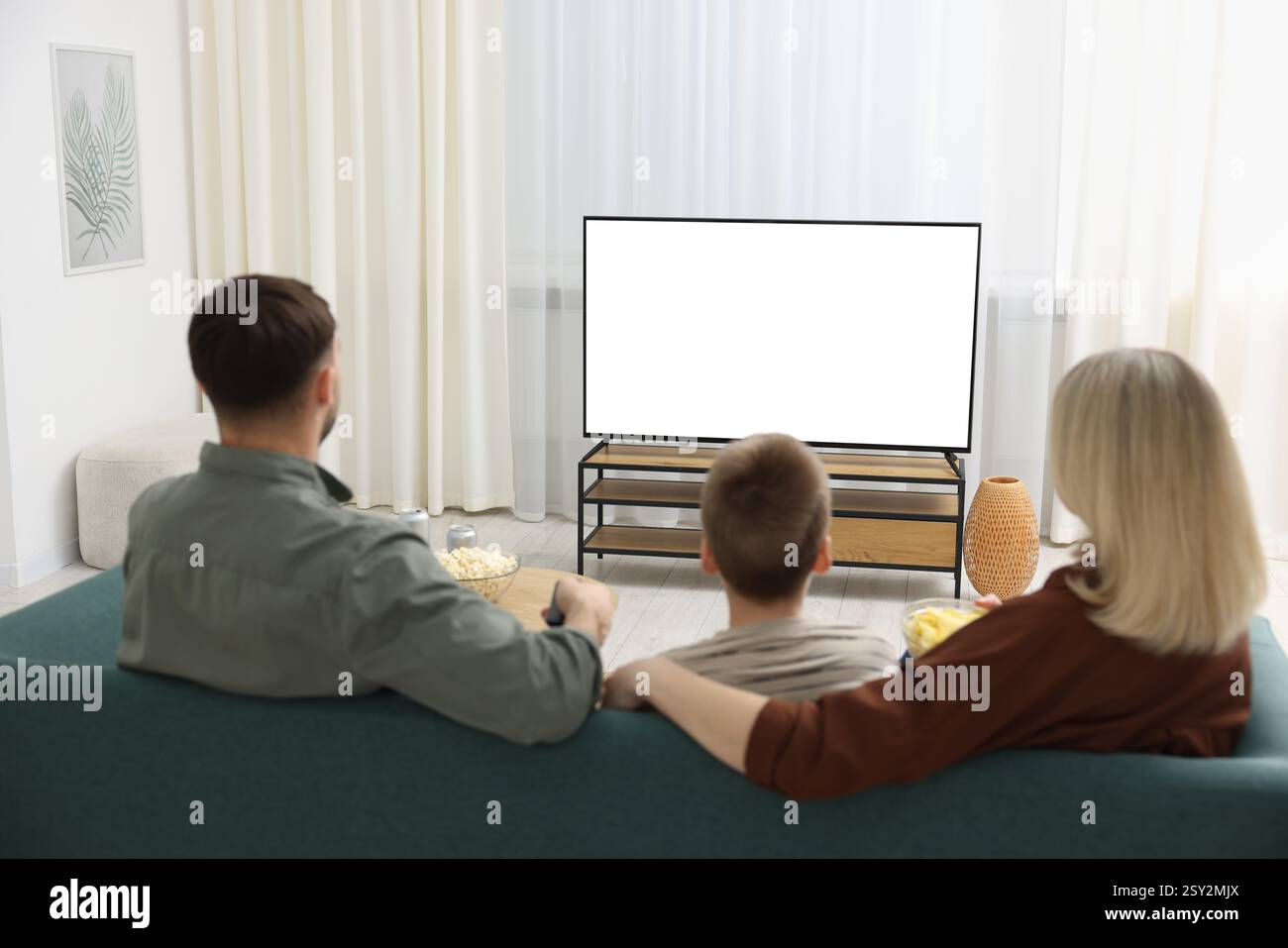 Happy family watching tv together at home, back view Stock Photo - Alamy