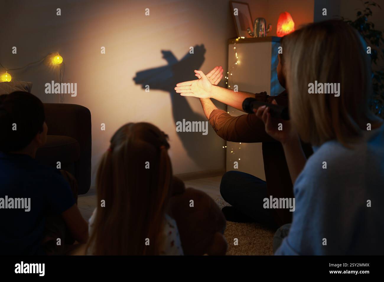 Man making hand gesture like bird while performing shadow play to his ...