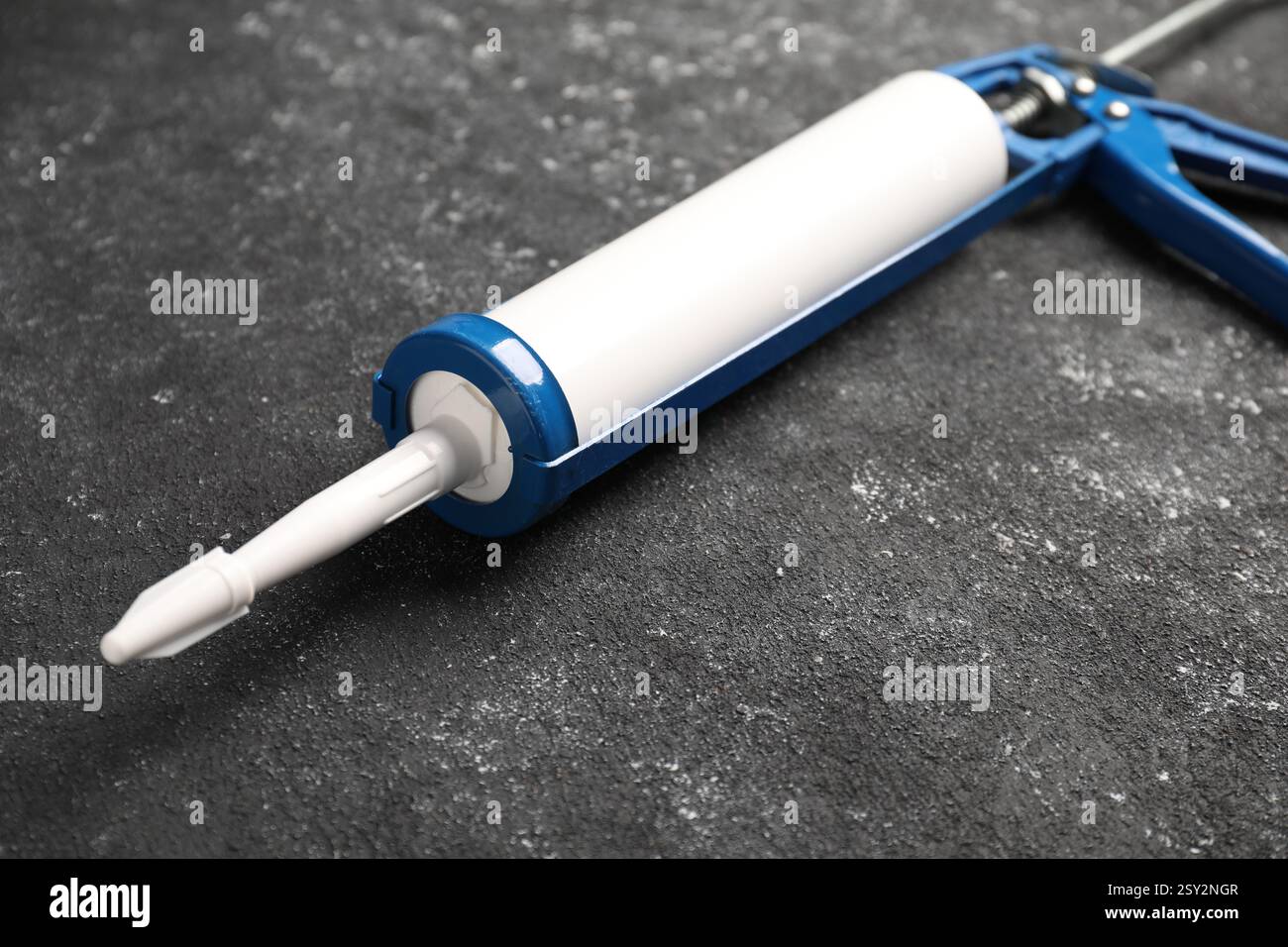 One glue gun on black textured background. Construction tool Stock ...