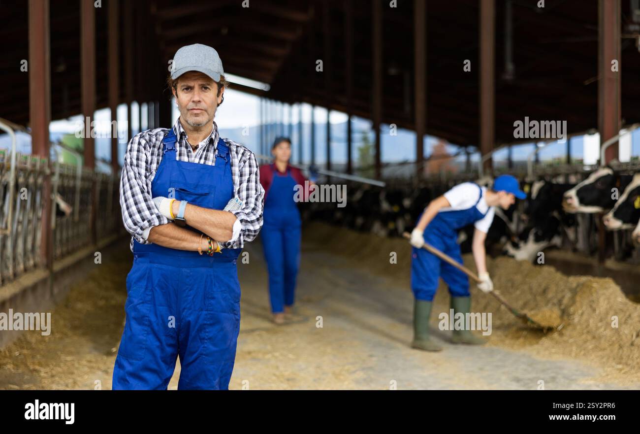 Confident middle-aged man, owner of farm looking at camera with crossed ...