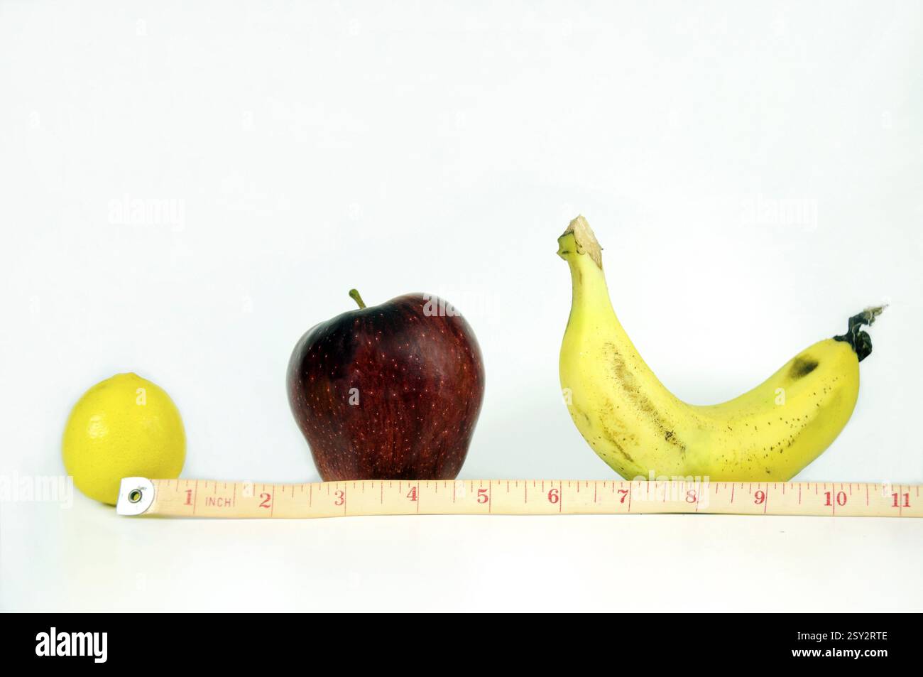 Measuring tape showing inches lemon apple banana on white background ...