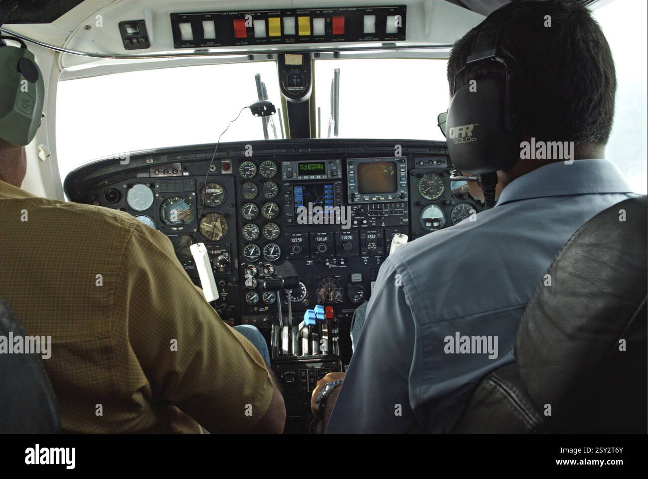 Pilots in cockpit of piper aircraft checking navigation, India, Asia ...