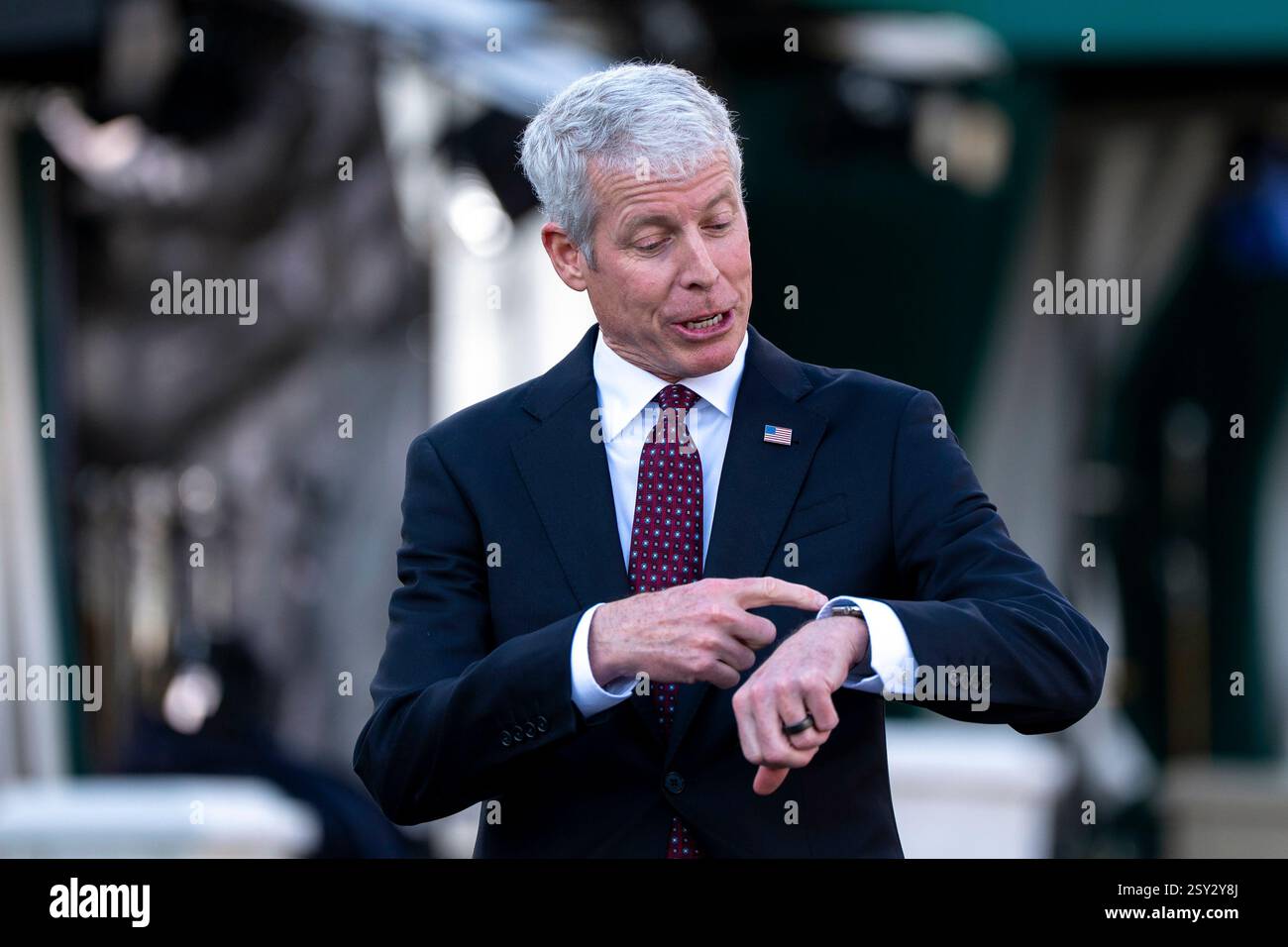 Energy Secretary Chris Wright checks his watch before speaking with ...