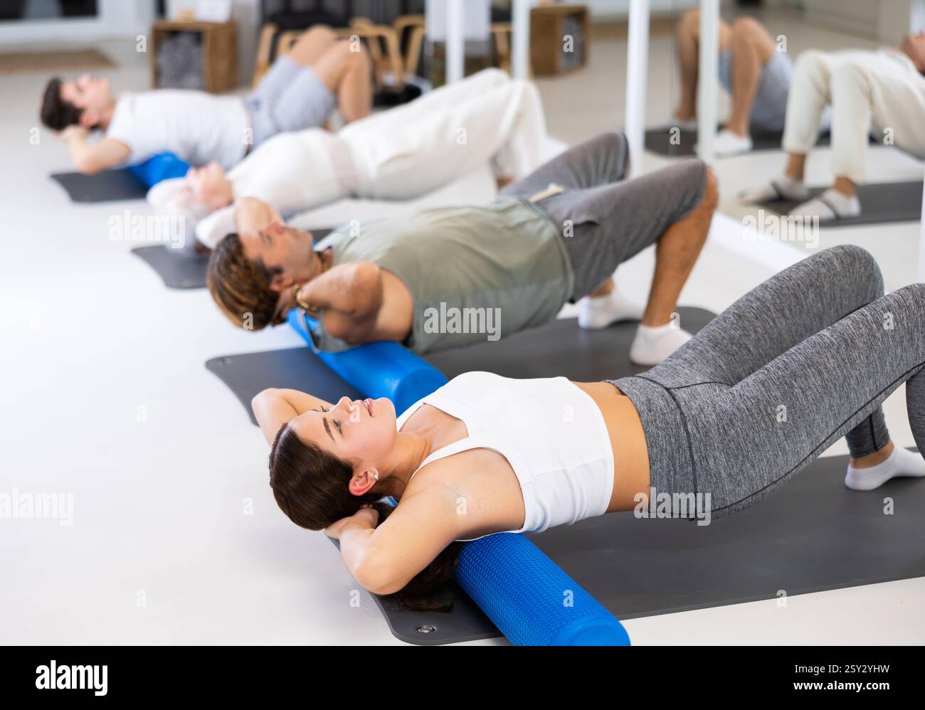 Group of different people doing exercises with roller Stock Photo - Alamy