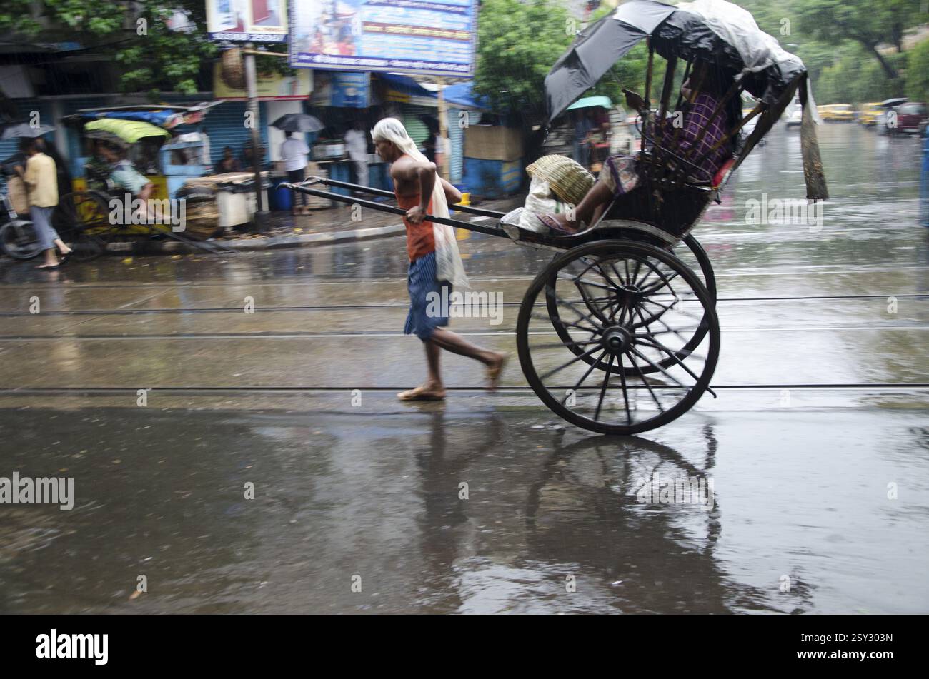 Man pulling Hand Rickshaw with passenger on street Kolkata West Bengal ...