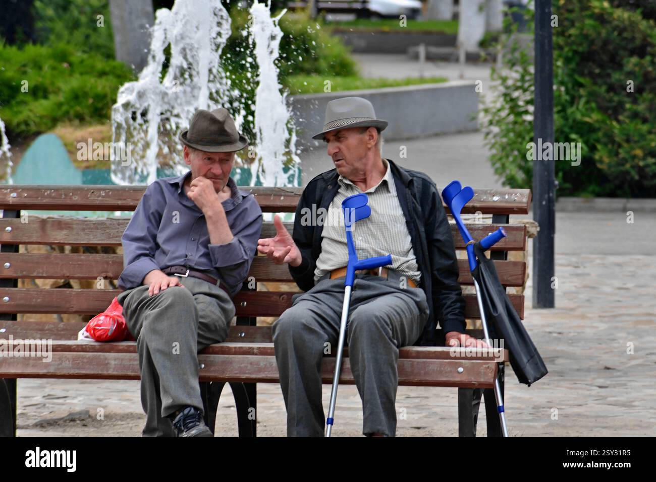 Two older men conversing on park bench Stock Photo - Alamy