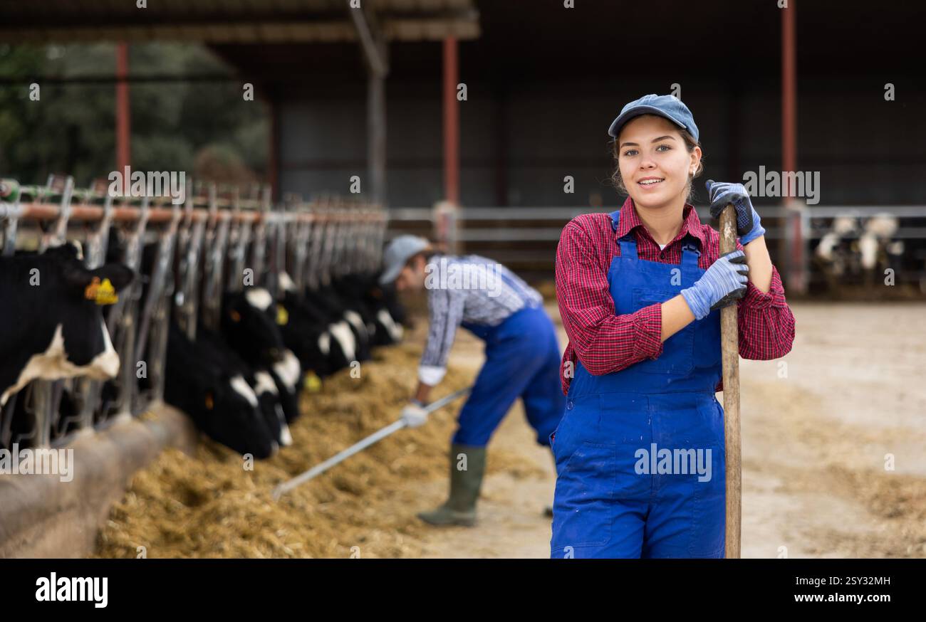 Farmer woman stands with rake at cow farm Stock Photo - Alamy