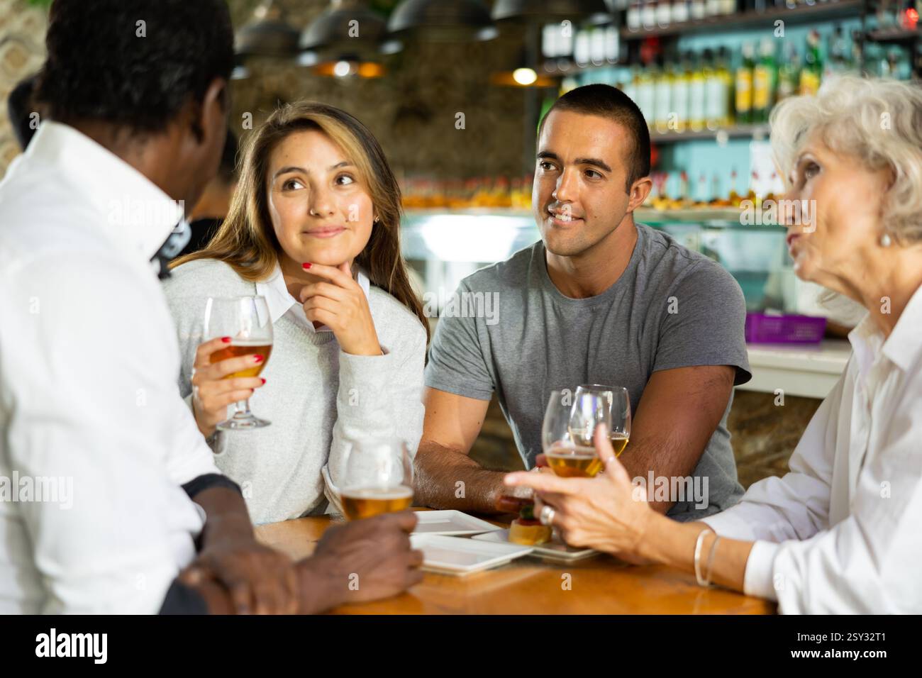 Happy diverse group having a conversation at a bar Stock Photo - Alamy