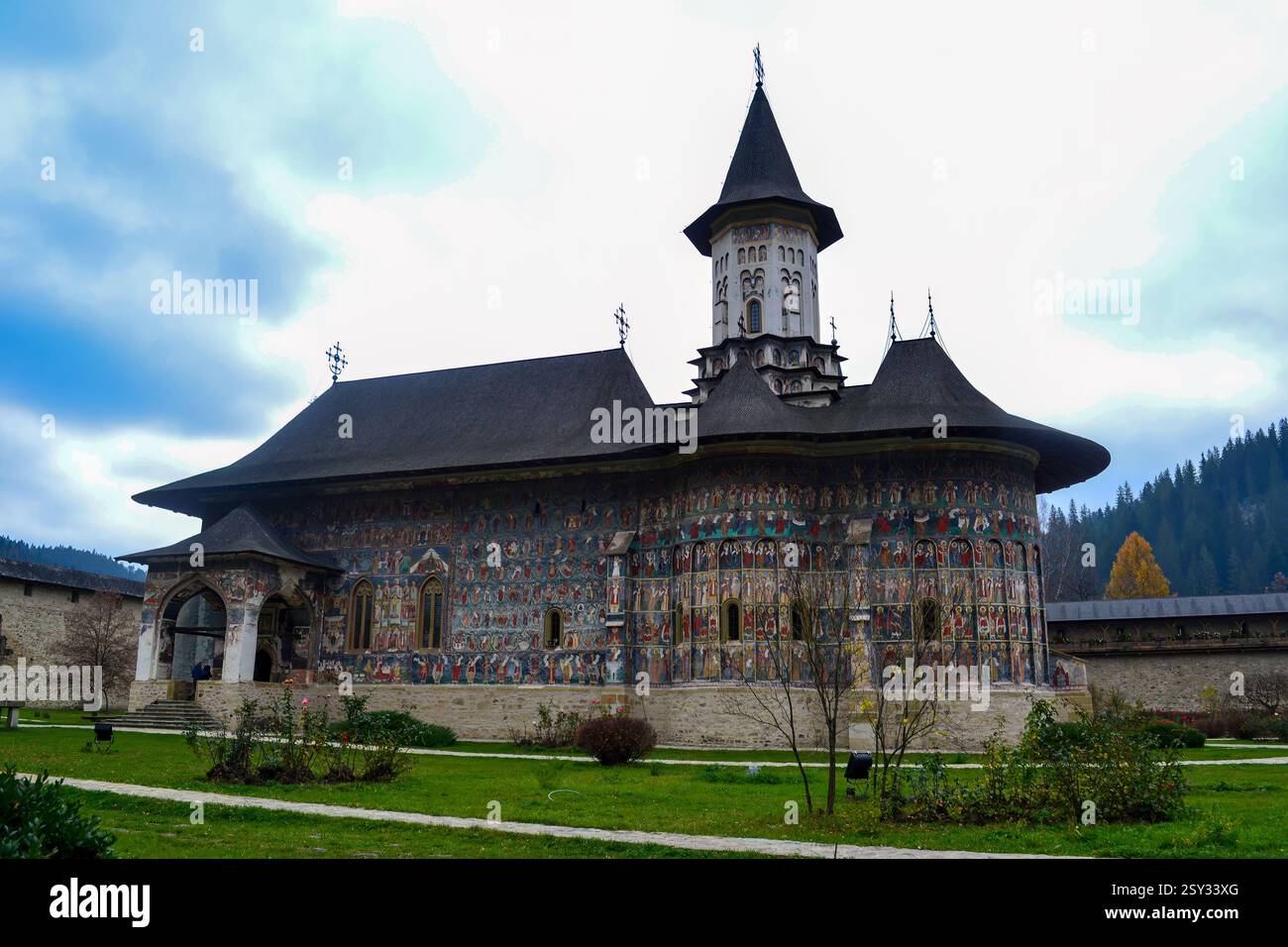 Voronet Monastery in Romania features intricate frescoes on vivid blue walls, a tall spire ...