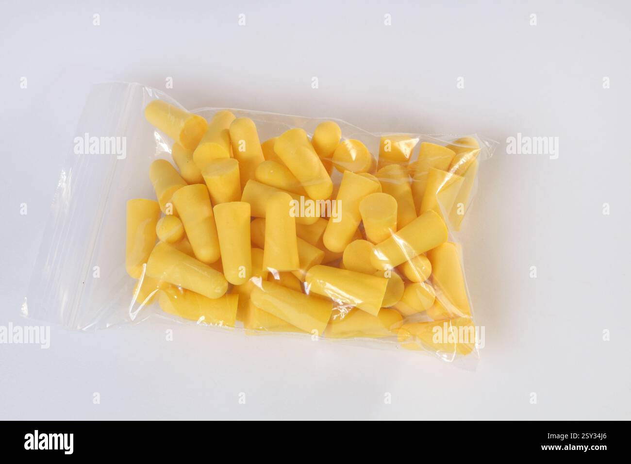 Yellow foam ear plugs in a plastic bag, health and safety items Stock ...
