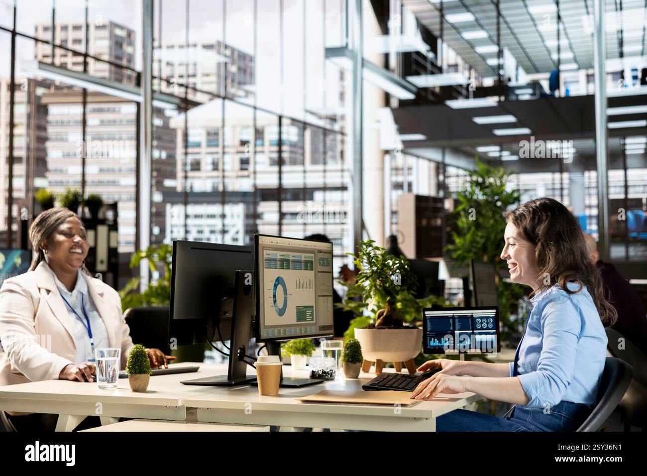 Young office employee overseeing business operations at workstation ...