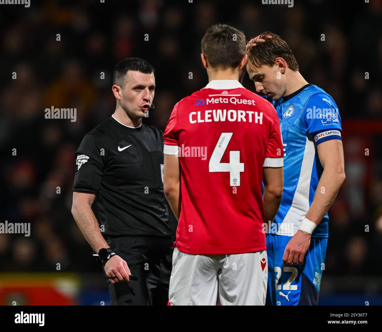 Referee Lewis Smith speaks to Max Cleworth of Wrexham and Hector ...