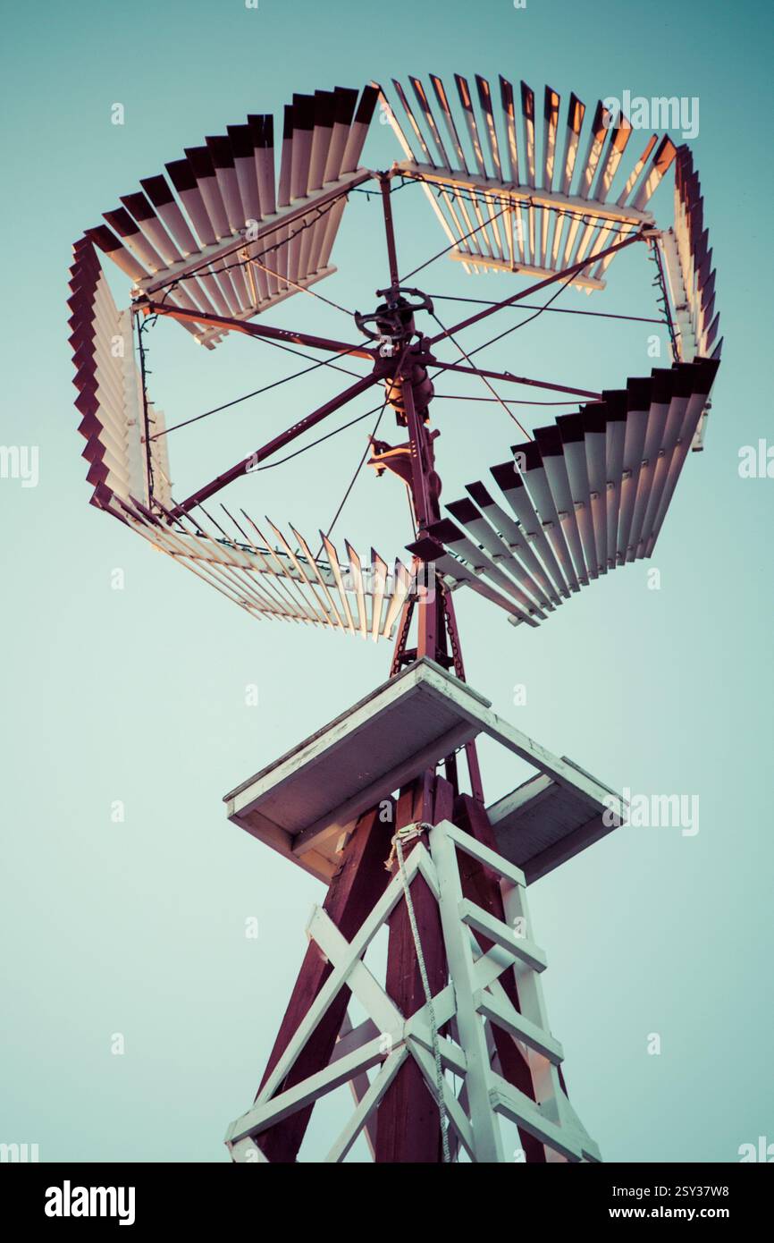 Windmill with a white top and red bottom. The windmill is on a pole Stock Photo - Alamy