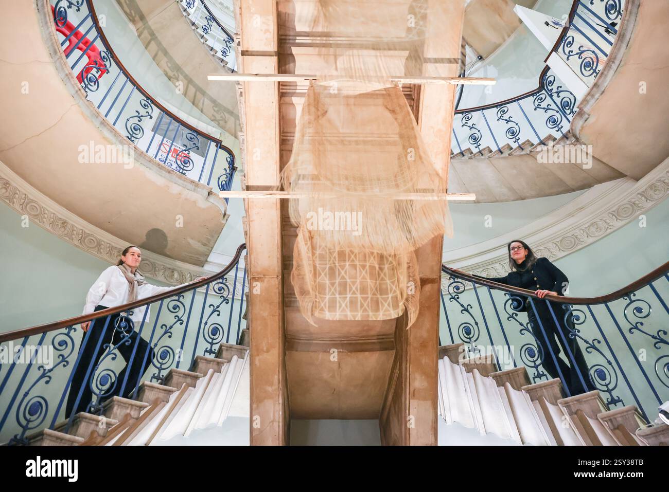 London, UK. 26th Feb, 2025. Staff pose with 'In the Drift of Paper' by ...
