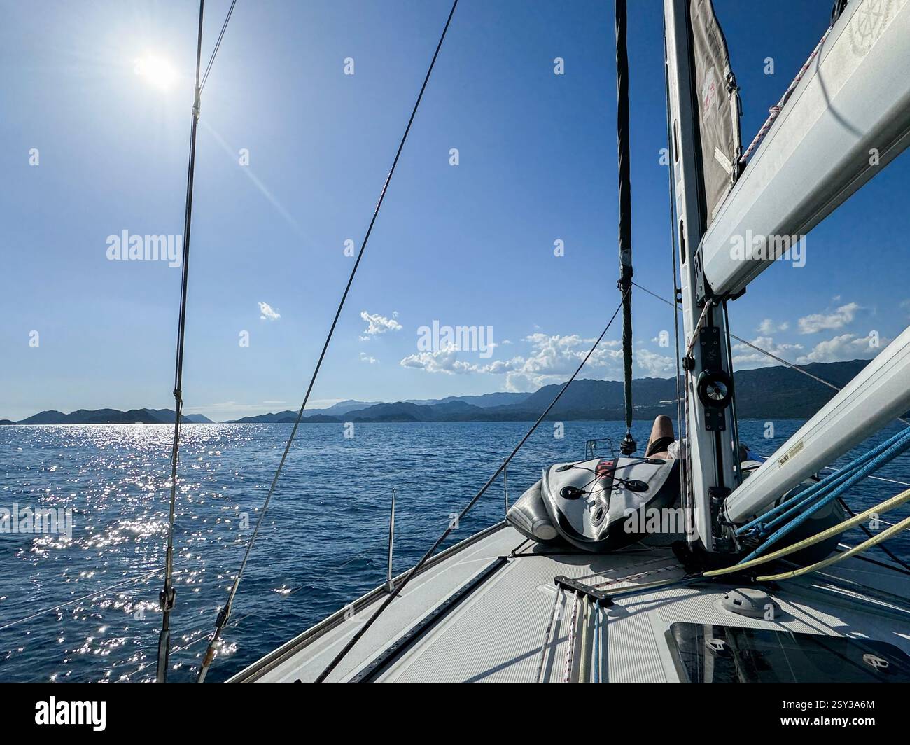 Sailing across calm waters under a bright sun in a picturesque coastal ...