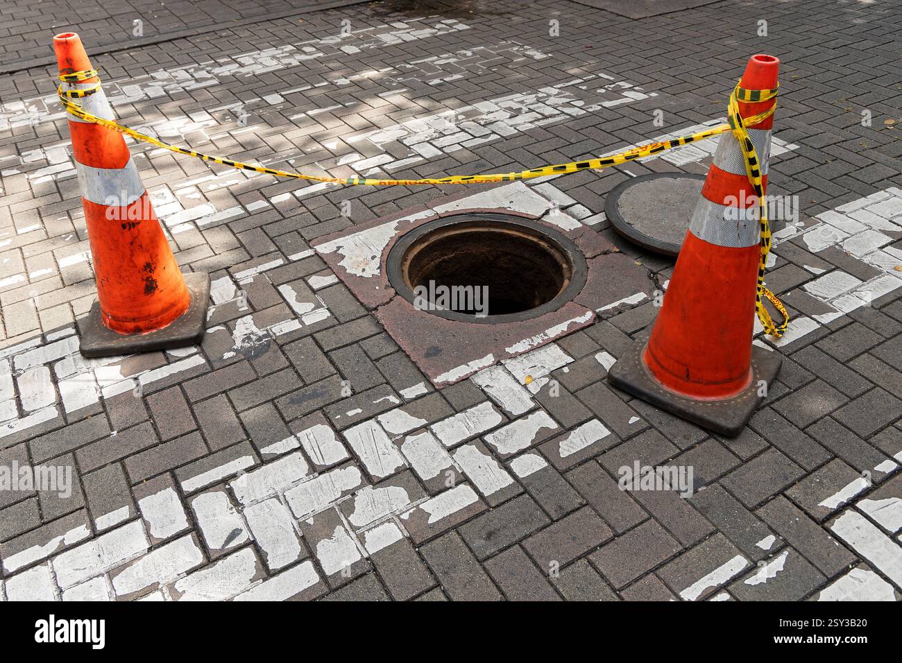 Traffic cones located at the entrance to the sewer - An open manhole ...